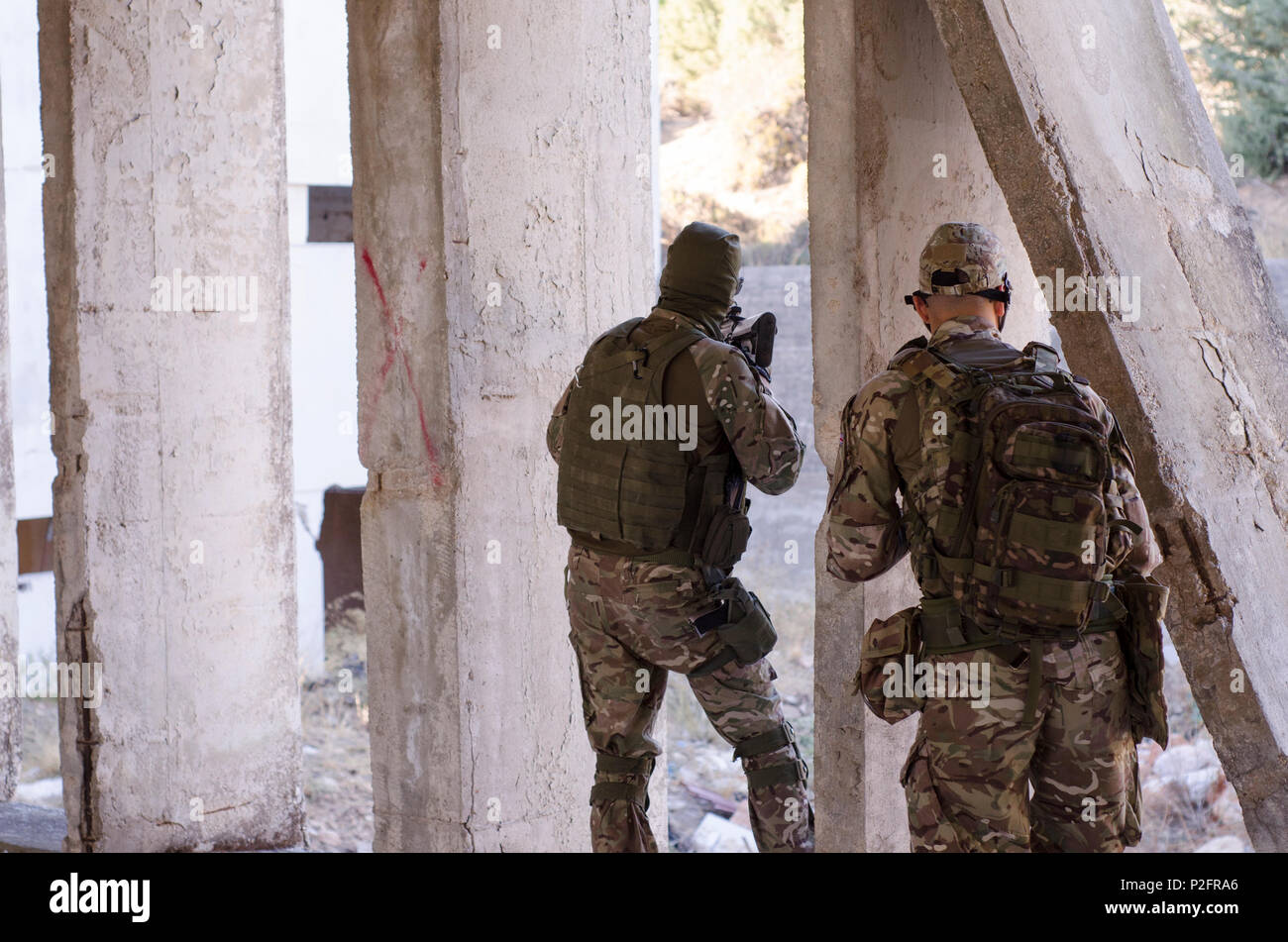 Two soldiers in combat back view inside building Stock Photo - Alamy