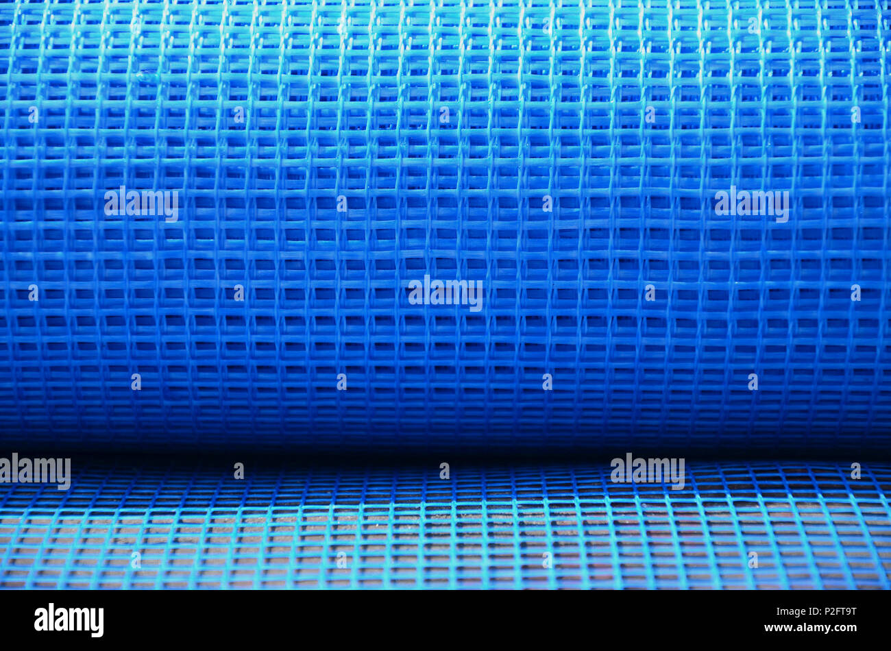 Close-up texture of a blue reinforcing mesh rolled up in a roll ...