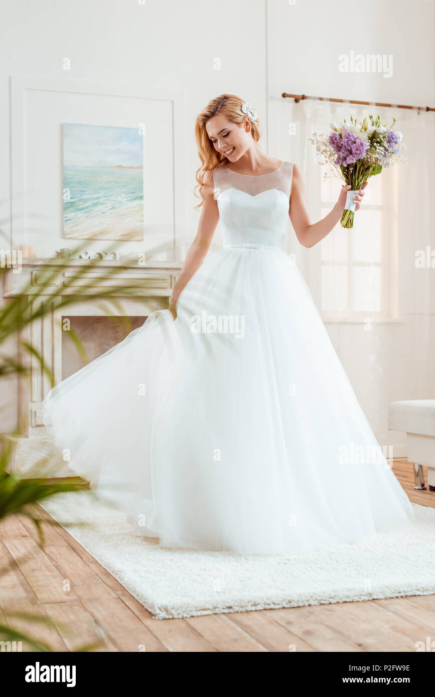 beautiful young bride in wedding dress in living room Stock Photo - Alamy