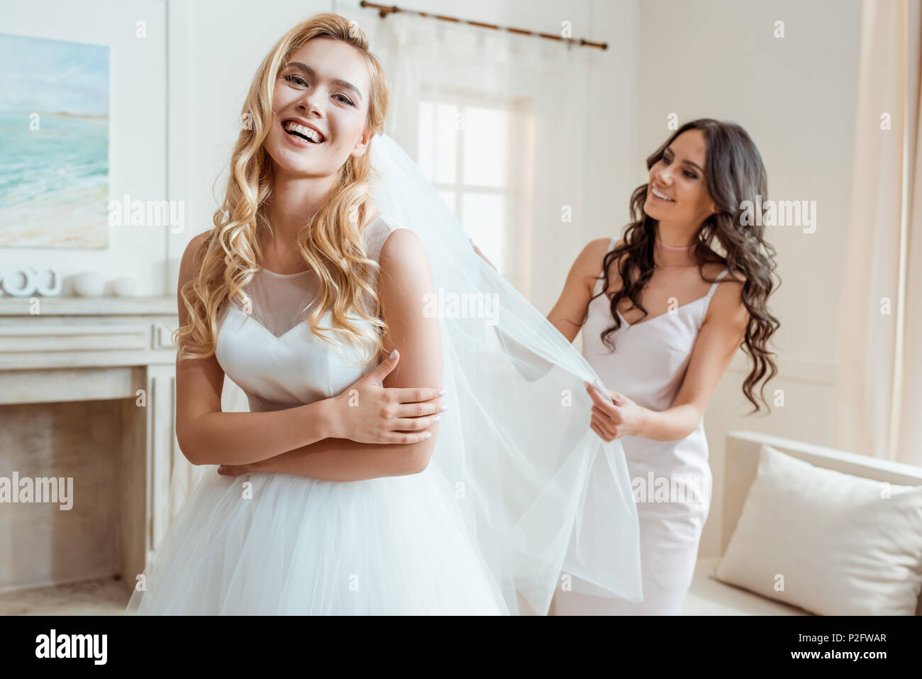 happy beautiful bridesmaid preparing laughing bride for wedding ...