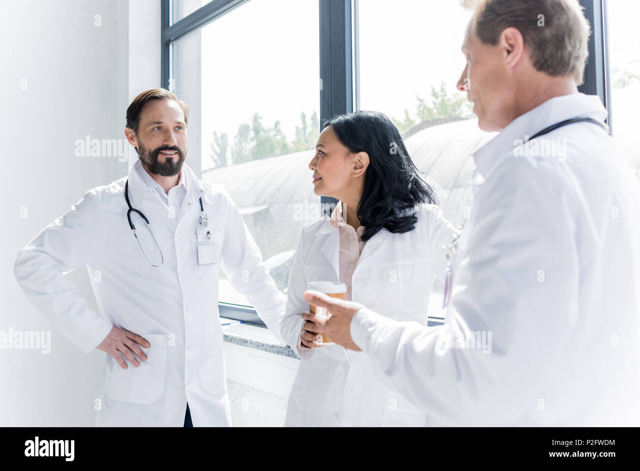 group of professional doctors talking and looking at each other in ...