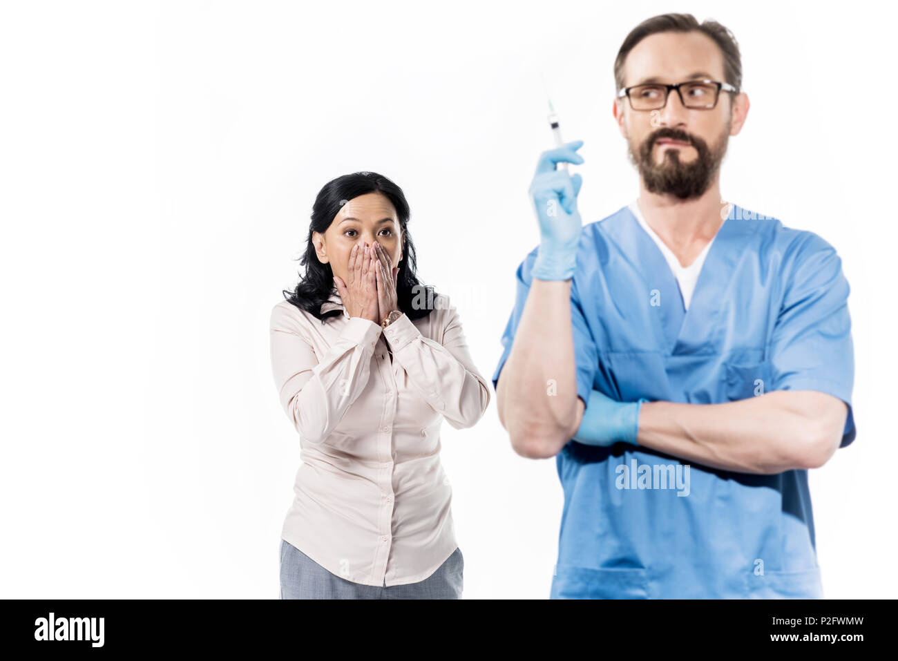 scared female patient looking at doctor with syringe, isolated on white ...