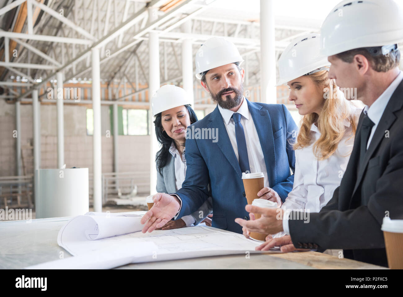 group of contractors in formal wear talking while working with ...