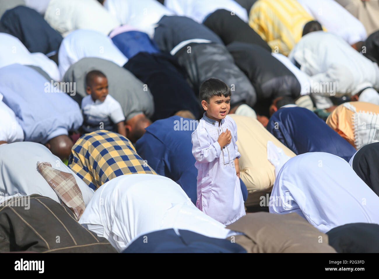 Moslem or Muslim men praying outside in Eid, with little boy standing ...