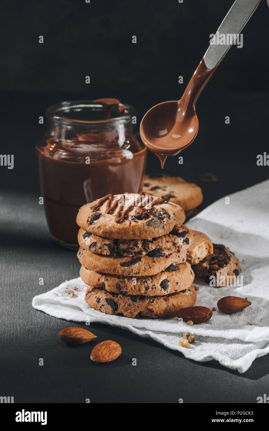 close-up shot of liquid chocolate pouring onto stacked chocolate-chip ...