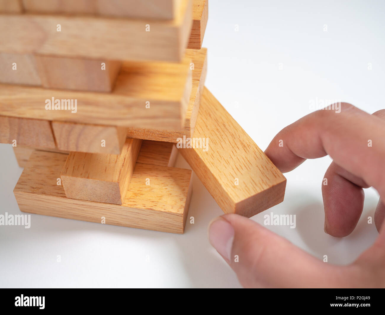 Hand Move out The Block Playing Tumble Tower Wooden Block Game on White ...