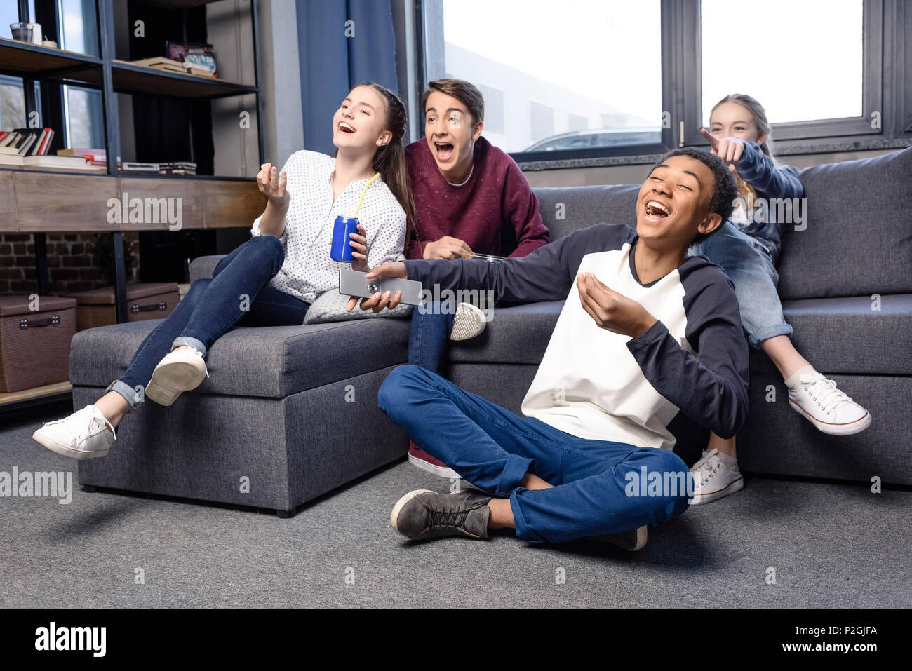 Happy group of teenagers watching movie together at home, teenagers ...