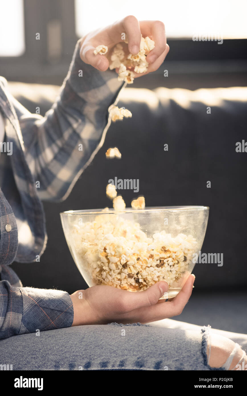 Close-up partial view of person eating popcorn from glass bowl Stock ...