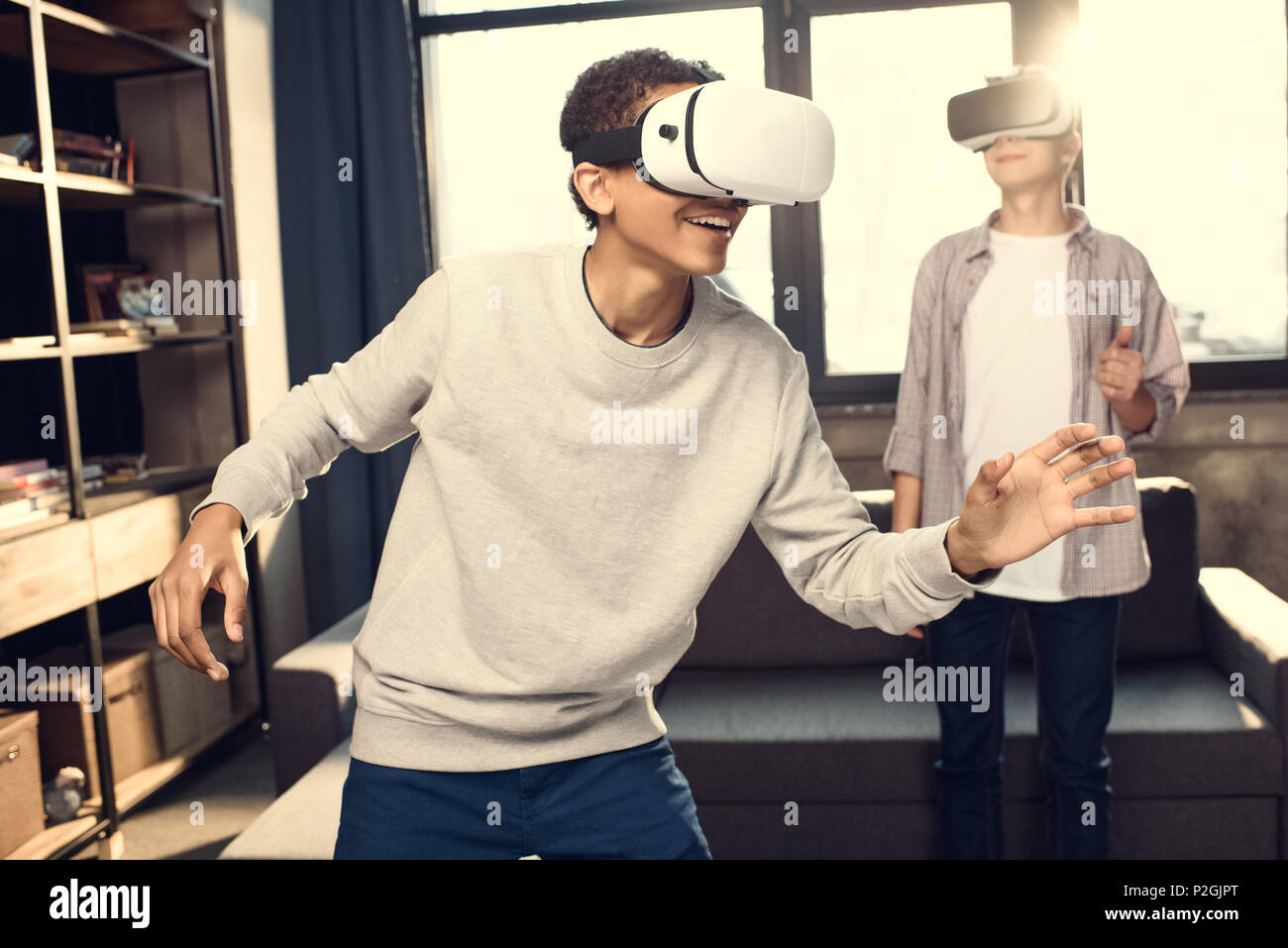 teenage boys wearing virtual reality headsets at home, teenagers ...