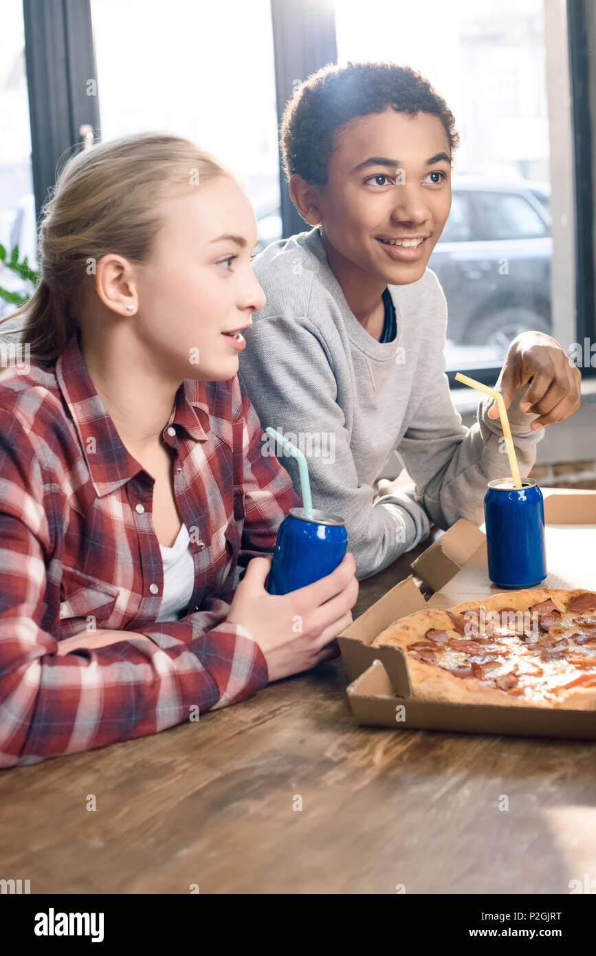 happy friends spending time together with pizza and soda drinks, eating ...