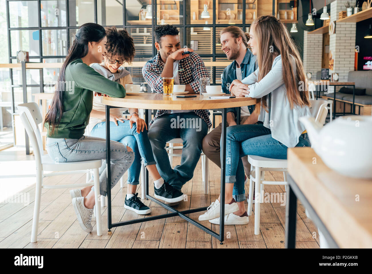 Group of young multiethnic friends spending good time together in cafe ...
