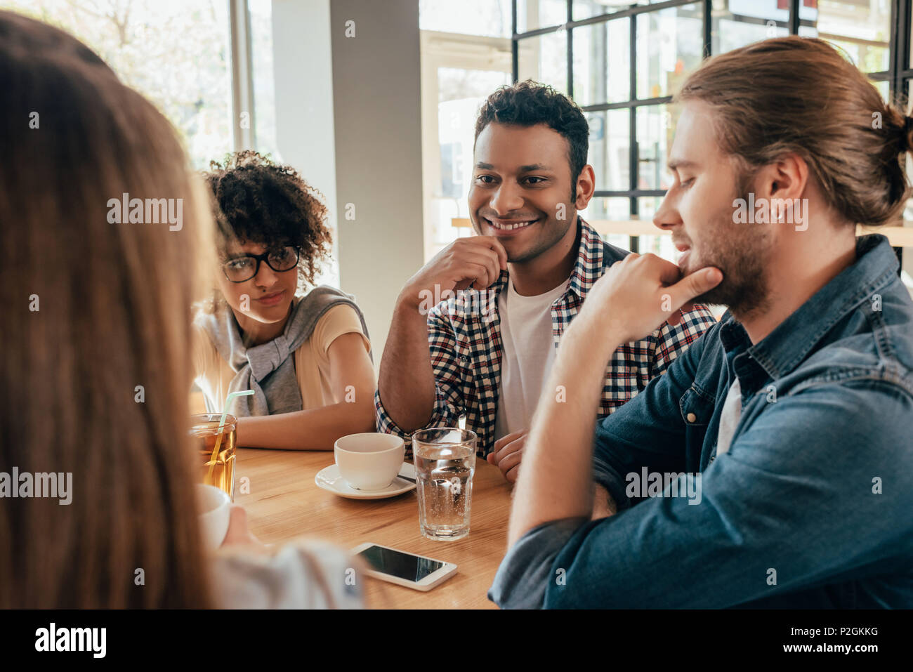 Group of young multiethnic friends spending good time together in cafe ...
