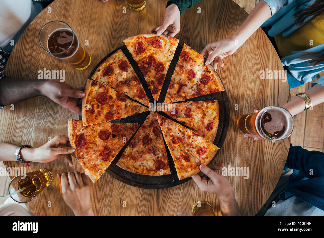 Top view group of young friends having pizza in cafe Stock Photo - Alamy