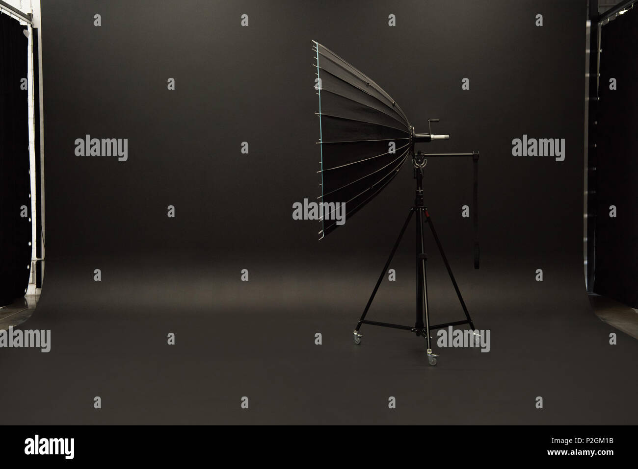Big studio light standing on black studio backdrop Stock Photo - Alamy