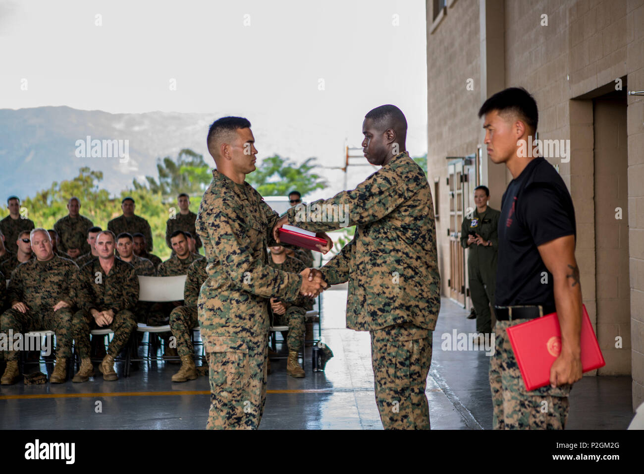 A Marine Master Sergeant presents a certificate to a Marine recognized ...