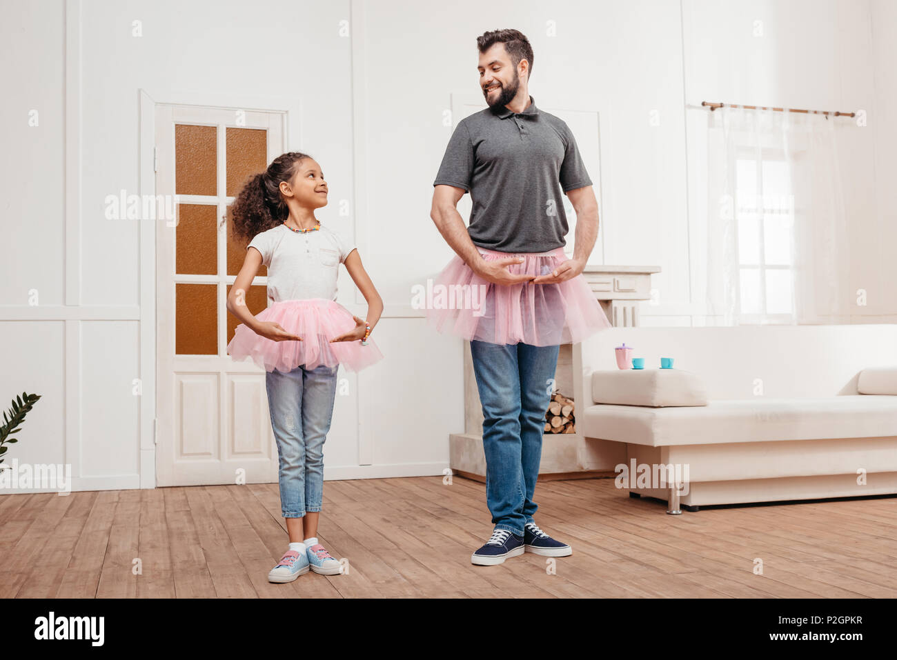 multicultural family in pink tutu tulle skirts dancing at home Stock ...