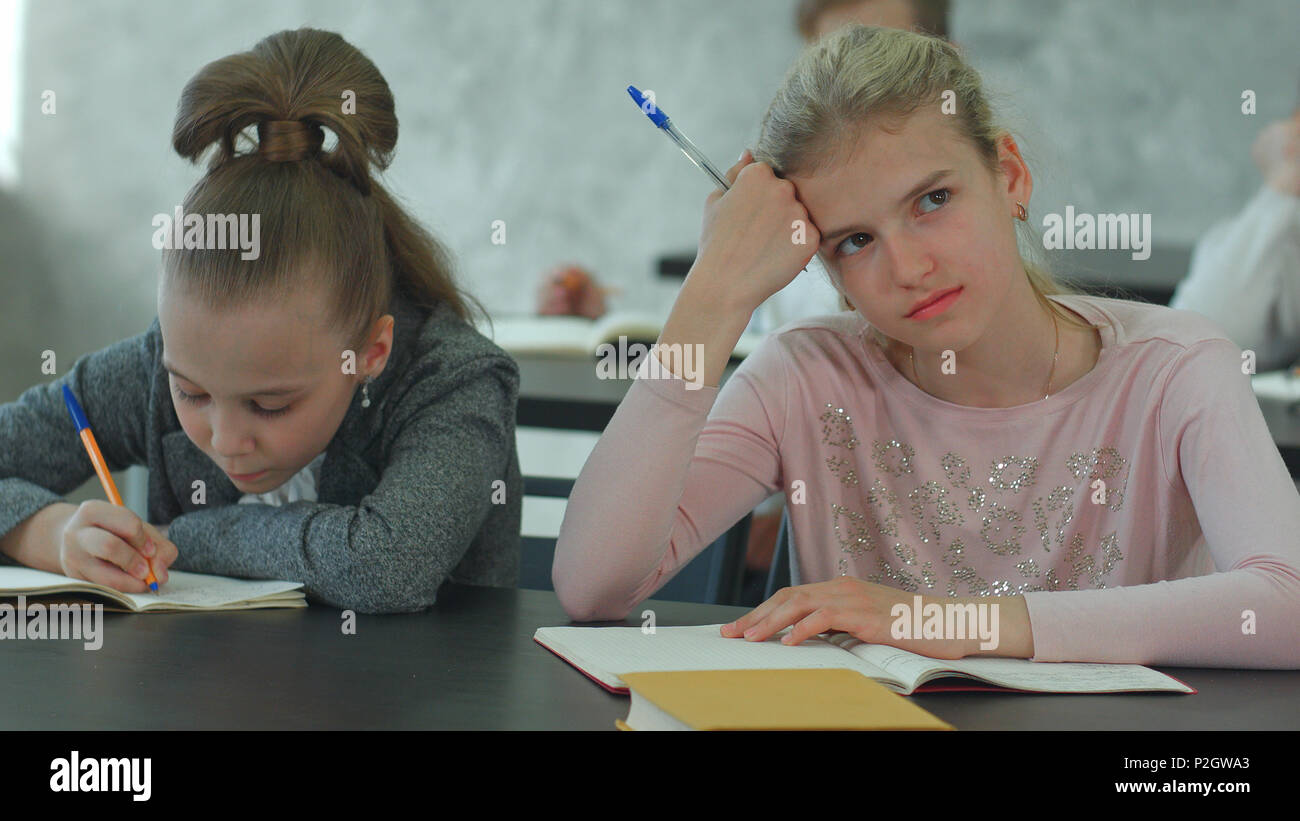 Primary school kids sitting at school class and listening to a teacher ...