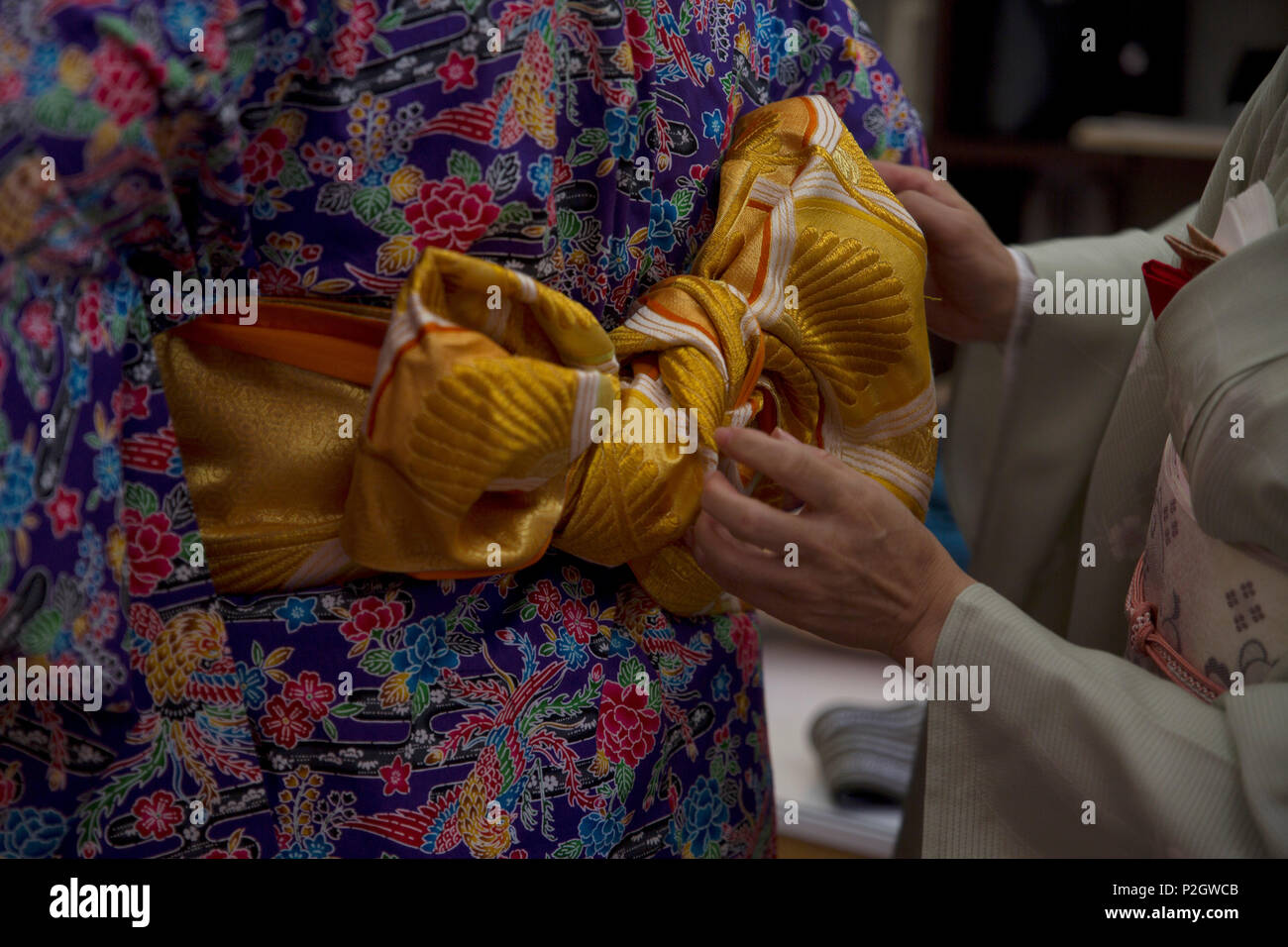 An instructor ties an obi, also known as a scarf, during a Japanese Tea ...
