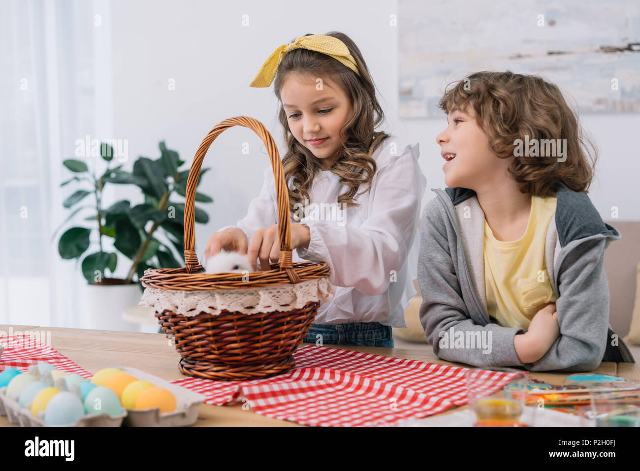 adorable little kids playing with cute rabbit in basket on table with ...