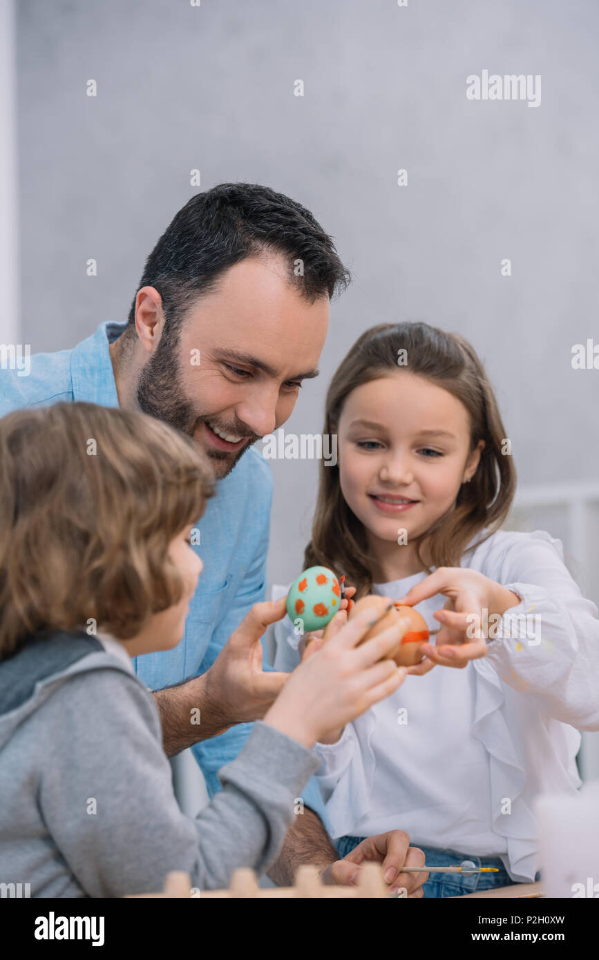 happy father painting easter eggs with kids Stock Photo - Alamy