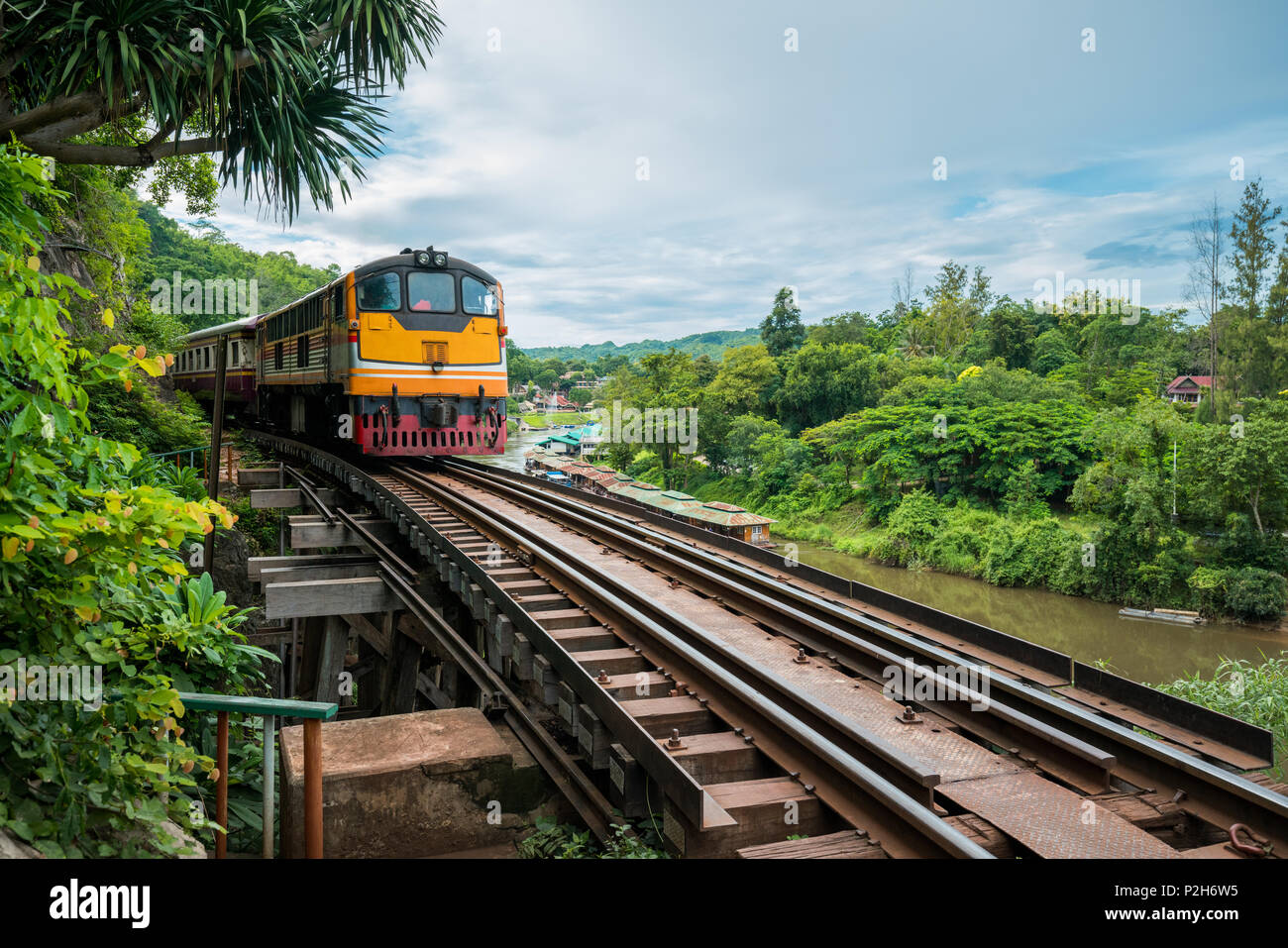 Old railroad tracks on bridge beside cliff rock Stock Photo - Alamy