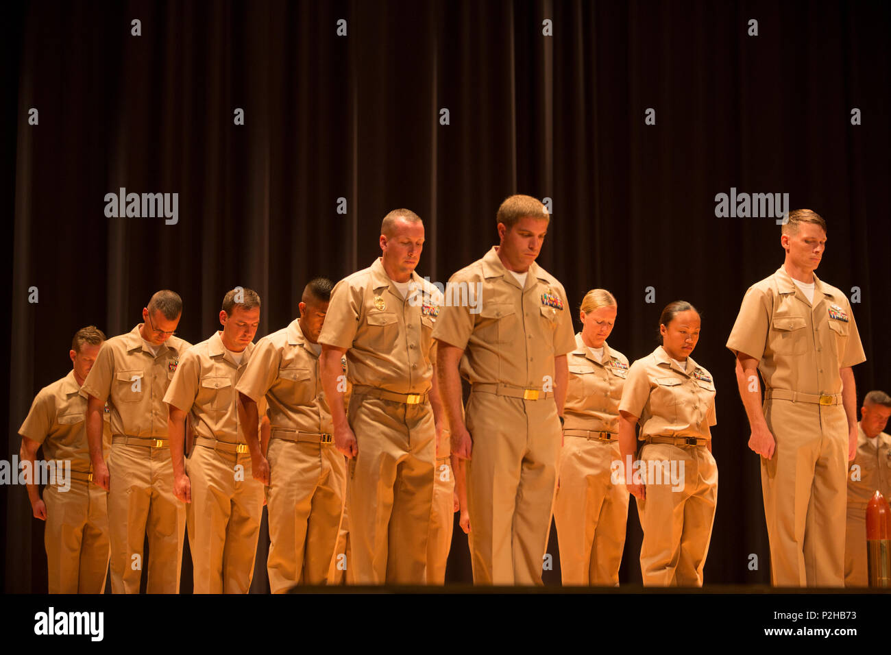 U.S. Navy Sailors bow their heads during the invocation delivered by ...
