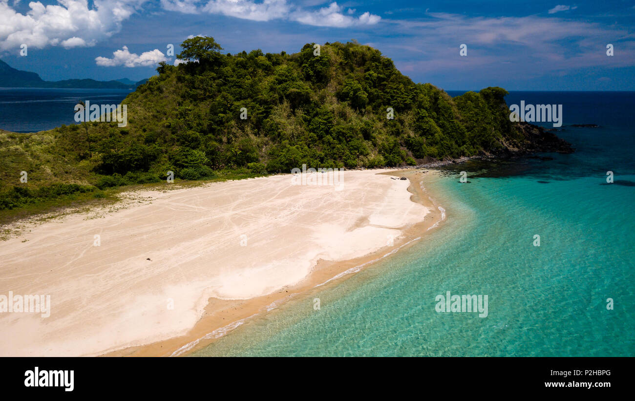 Aerial drone view of a large, empty tropical sandy beach and clear ...