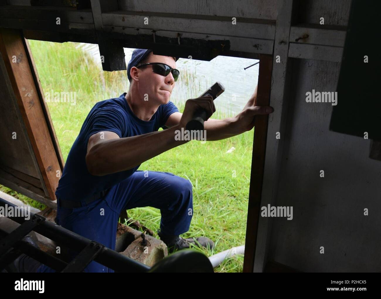 U.S. Coast Guard Petty Officer 3rd Class Austin Holbrook, a damage ...