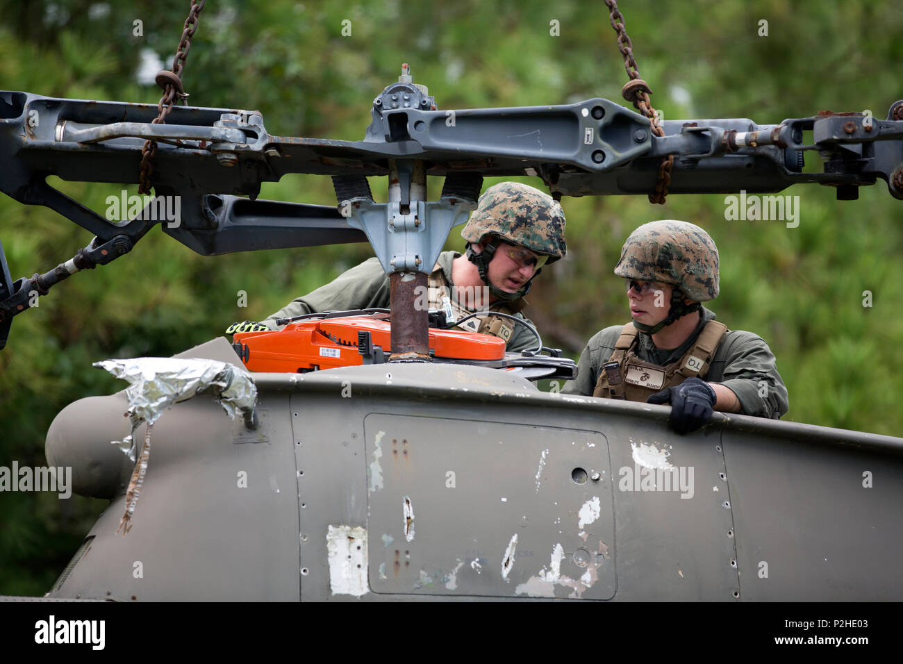 Cpl. Tyler Hallinan (right) demonstrates proper sawing techniques to ...