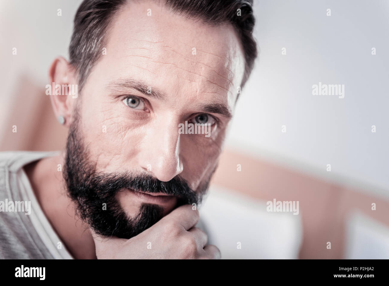 Serious man holding his chin Stock Photo - Alamy