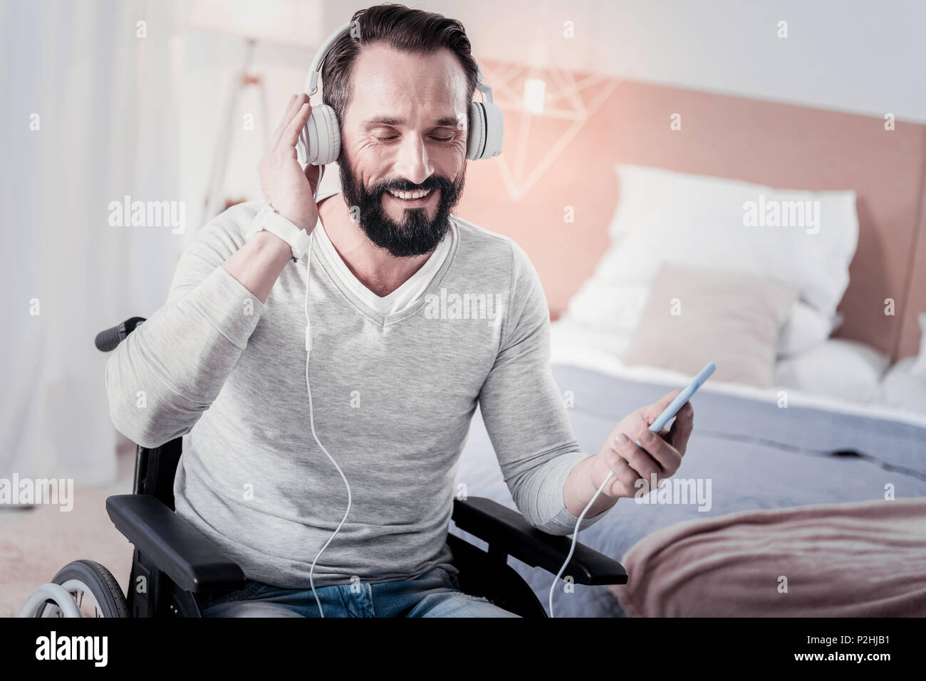 Cheerful crippled man listening to music Stock Photo - Alamy