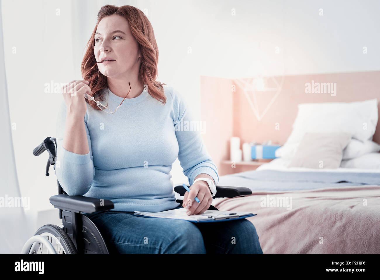 Concentrated young disabled woman thinking Stock Photo - Alamy