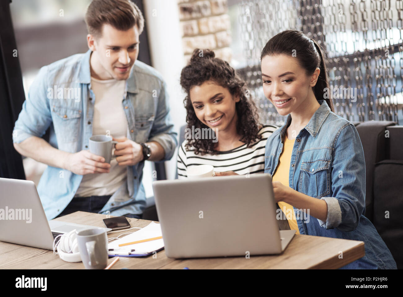 Happy joyful students looking at the laptop screen Stock Photo - Alamy