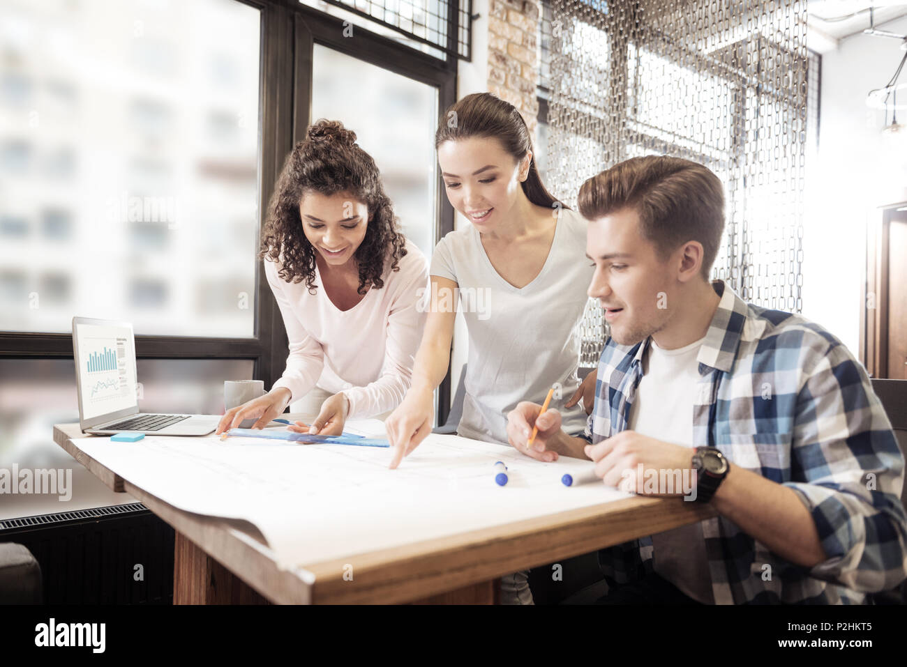 Nice smart people working on the drawing Stock Photo - Alamy