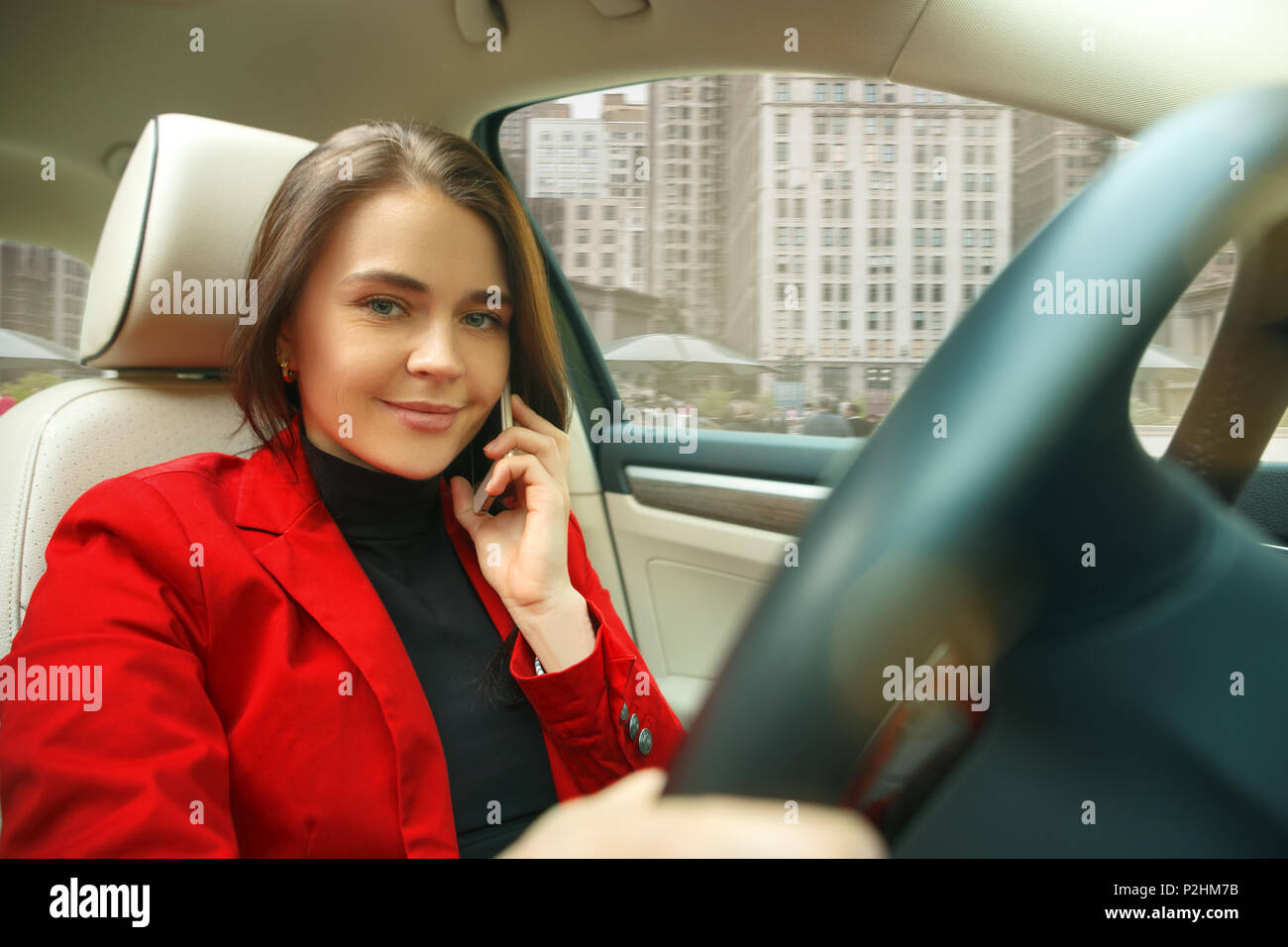 Driving around city. Young attractive woman driving a car Stock Photo ...