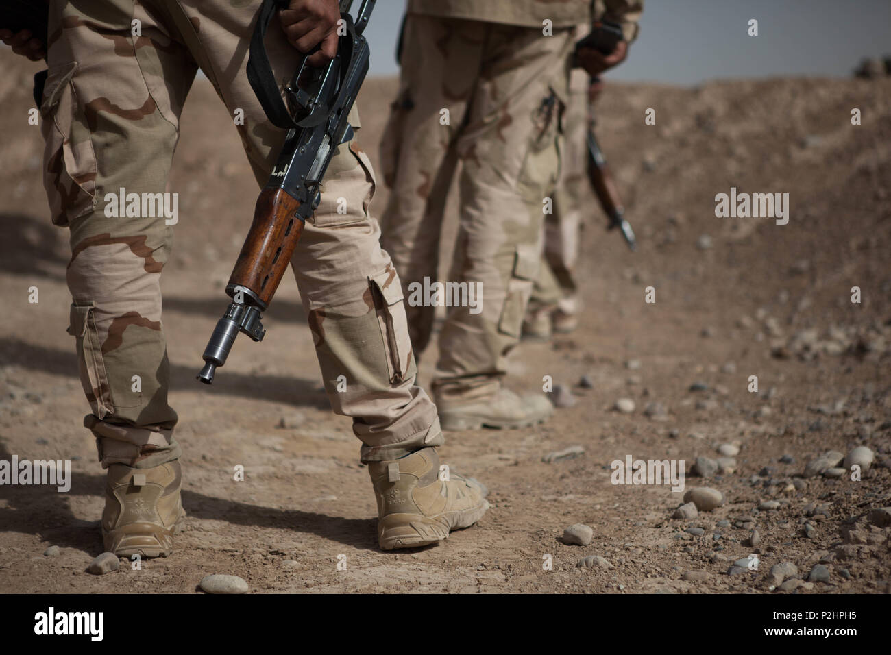 Iraqi soldiers hold their AK-47 rifles and listen to instructions ...