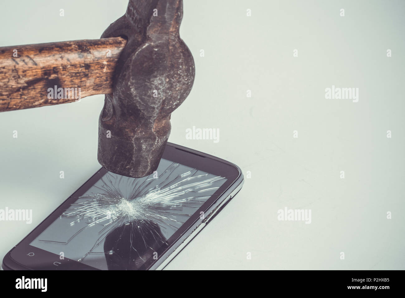 black broken phone, on white background, hammer on screen, after ...