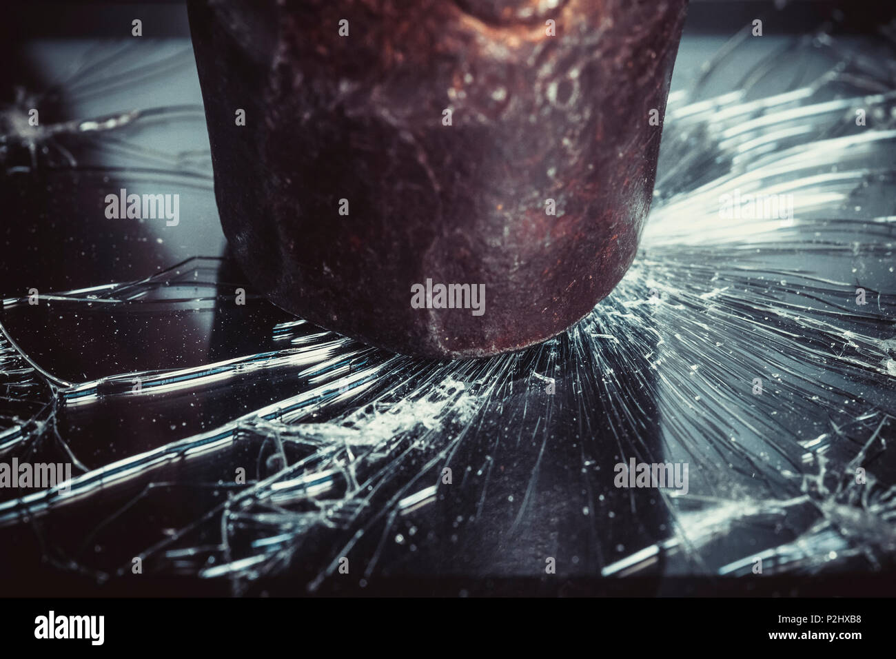 Hammer on a broken mobile screen, after hitting, toned background image ...