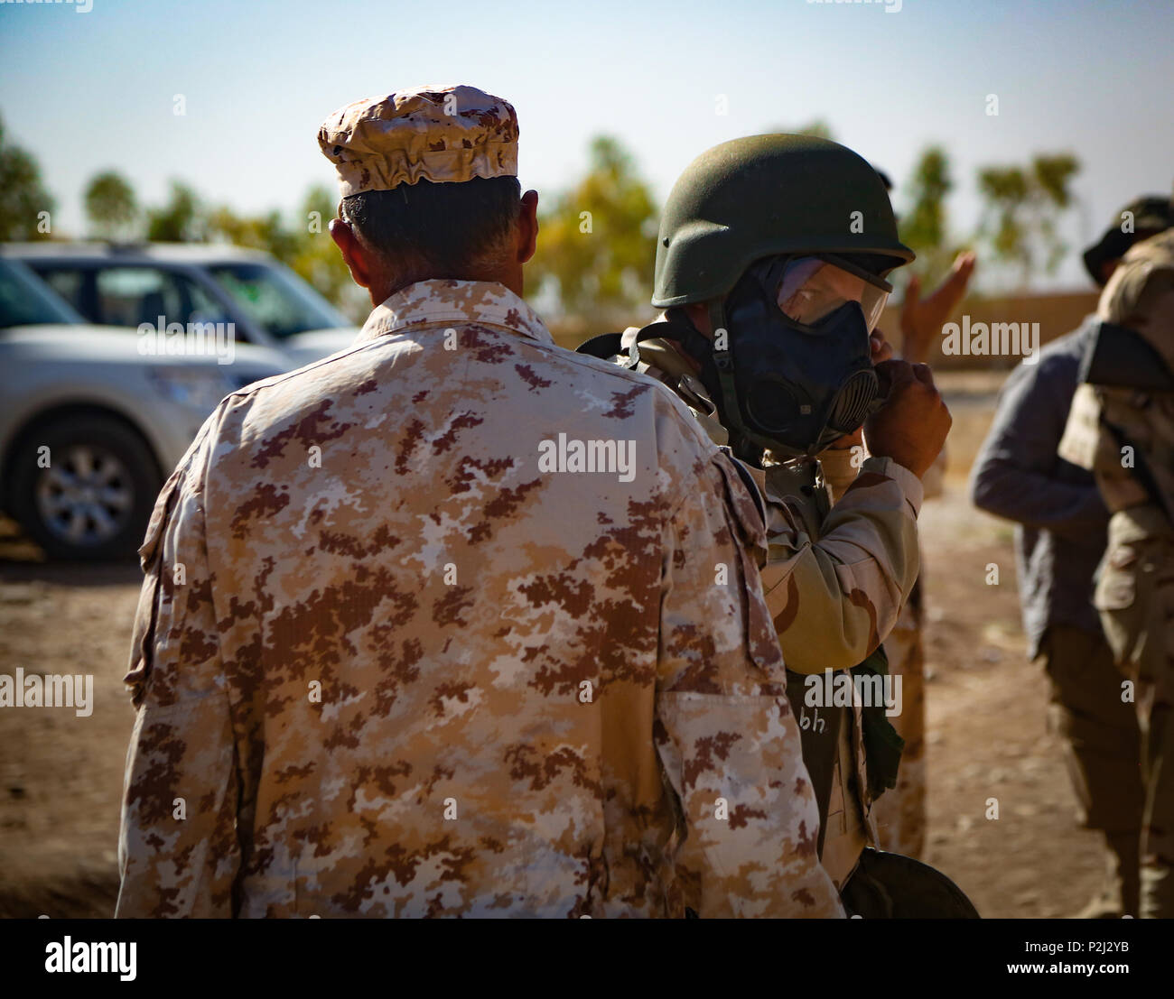 An Italian trainer instructs a Peshmerga soldier on how to don his ...