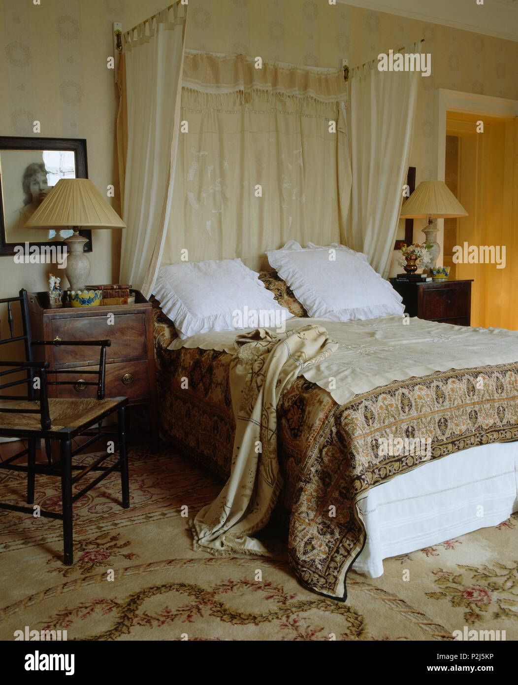 White pillows and patterned throw on antique half-tester bed with cream ...