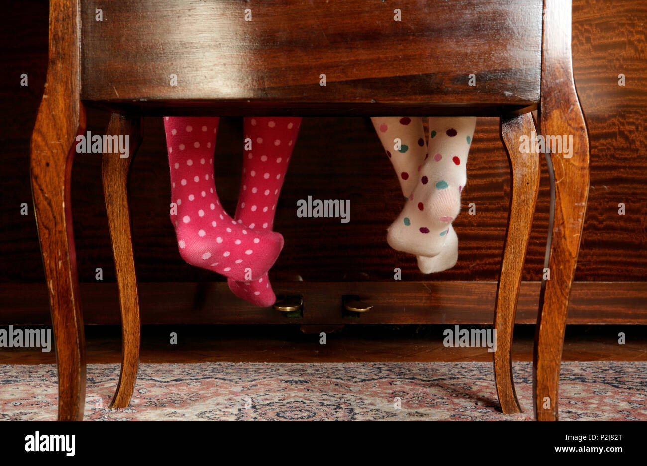 legs swinging on a piano stool as two young girls play Stock Photo - Alamy