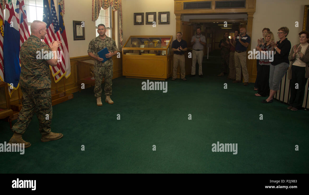 U.S. Service members and civilians applaud U.S. Navy Capt. Christopher ...