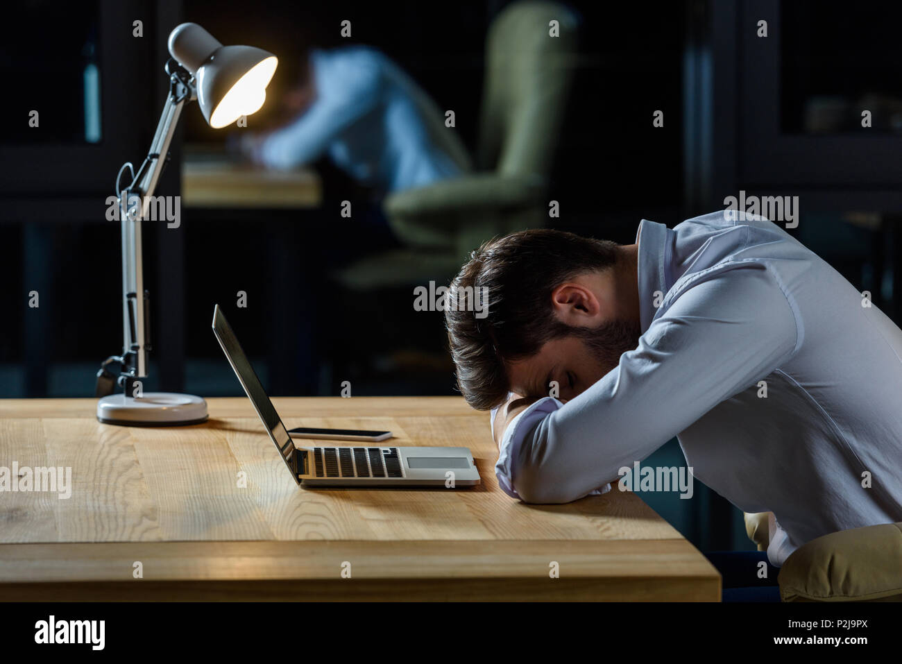 side view of tired businessman sleeping at table with laptop Stock ...