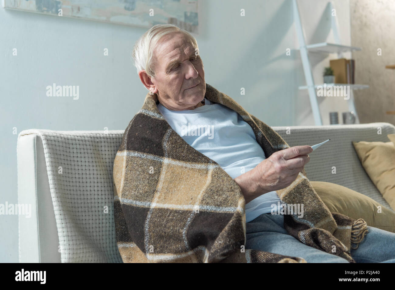 Senior man checking body temperature with thermometer Stock Photo - Alamy