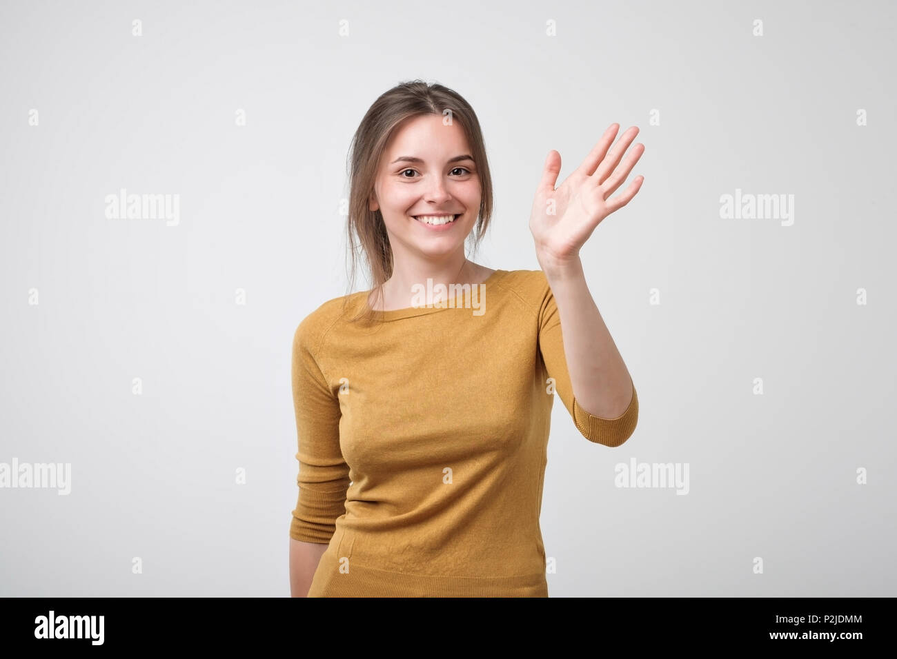Friendly-looking european teenager dressed in yellow pulover saying ...