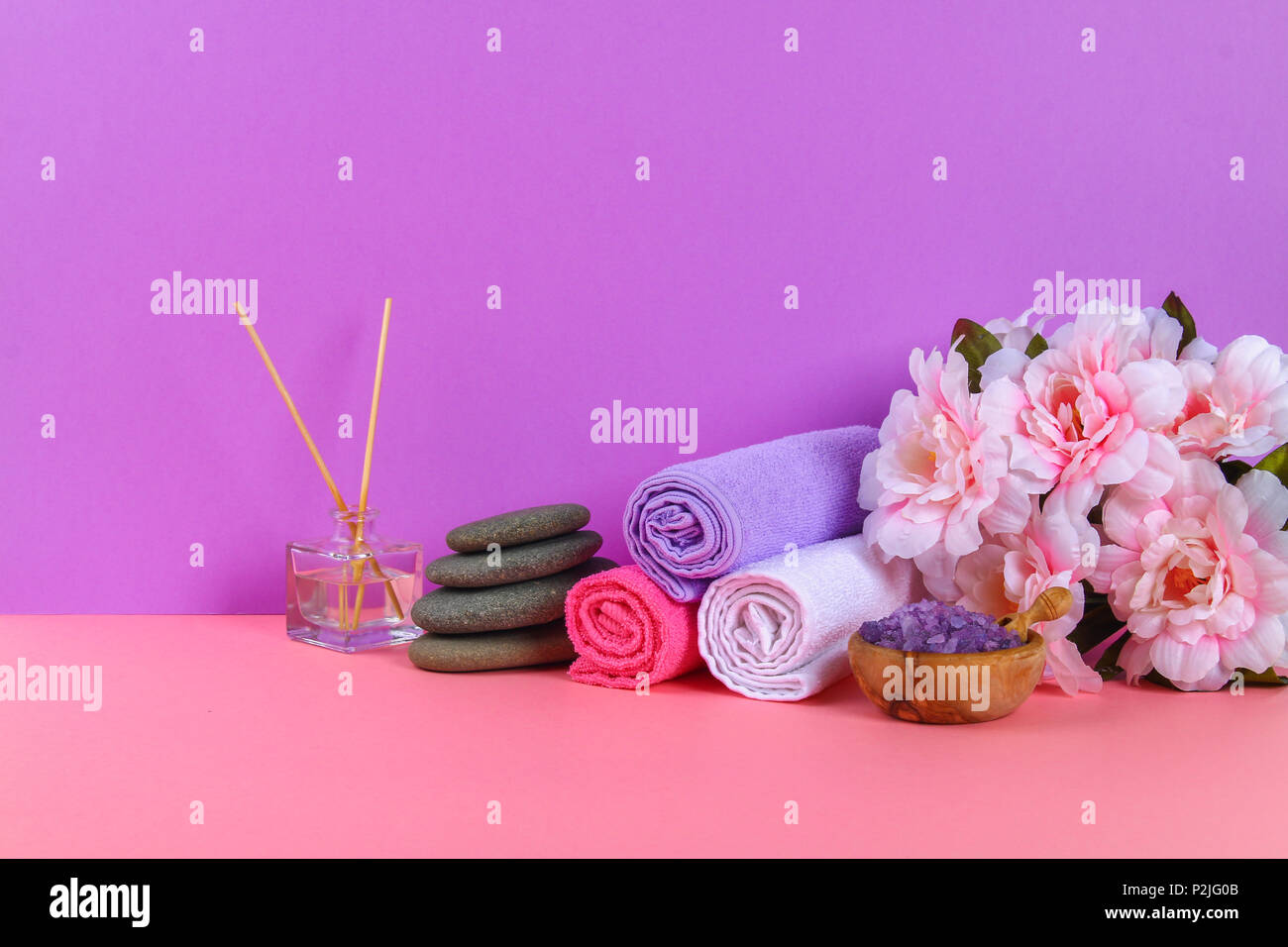 Spa on a pink pastel background. Towels, stones, aromamaslo, purple ...