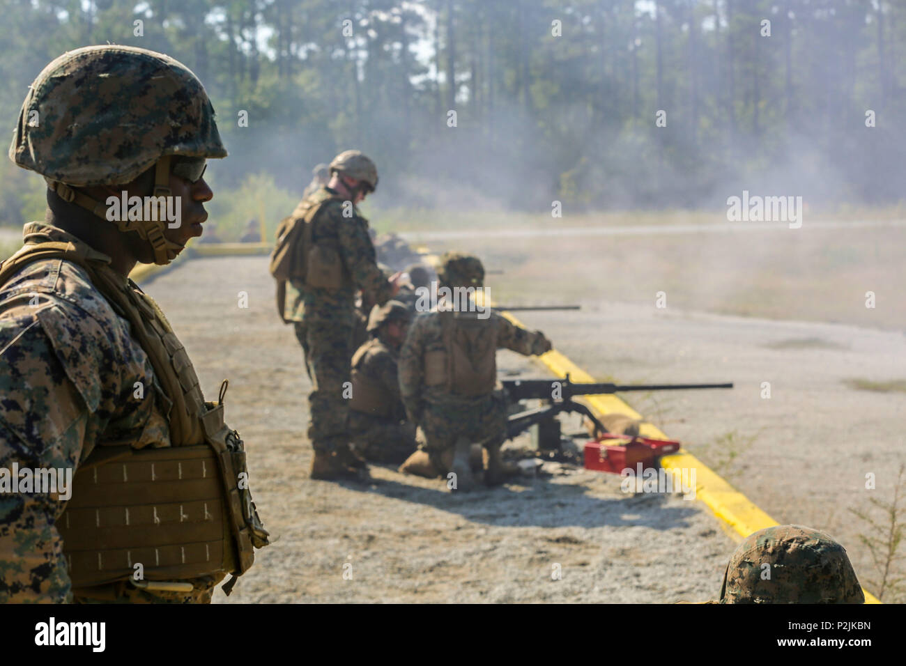 A U.S. Marine Corps instructor supervises Marines as they fire .50 ...