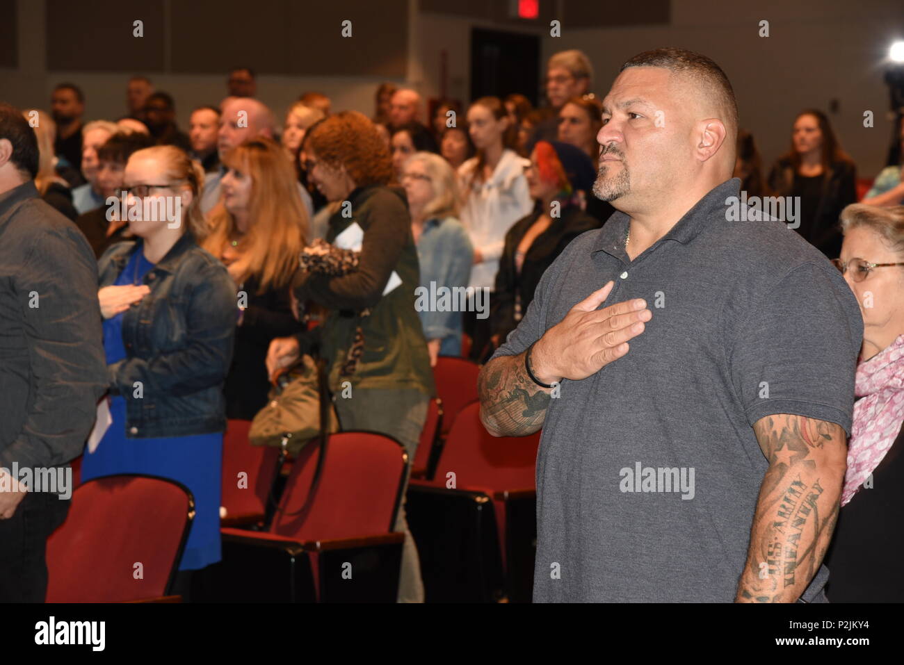 Family members stand for the playing of the national anthem during the ...