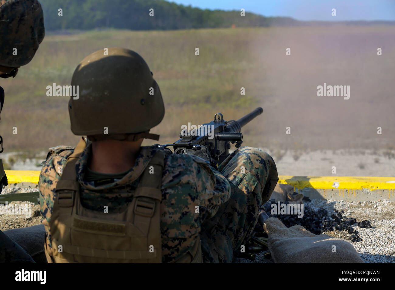 A Marine fires a .50 caliber machine gun during a machine gun range at ...