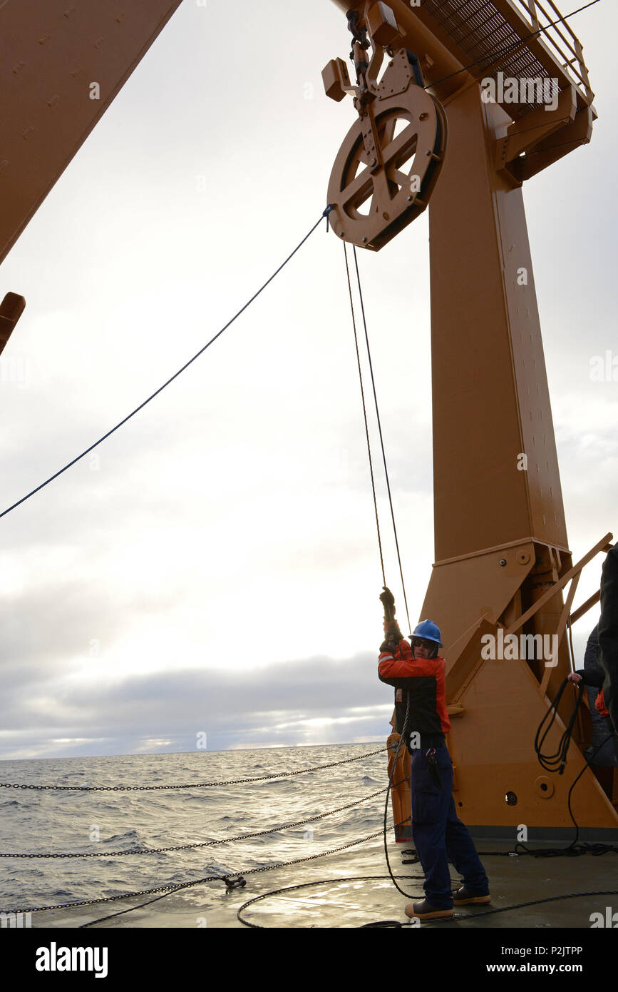 A crewmember aboard Coast Guard Cutter Healy resets the cable on a ...